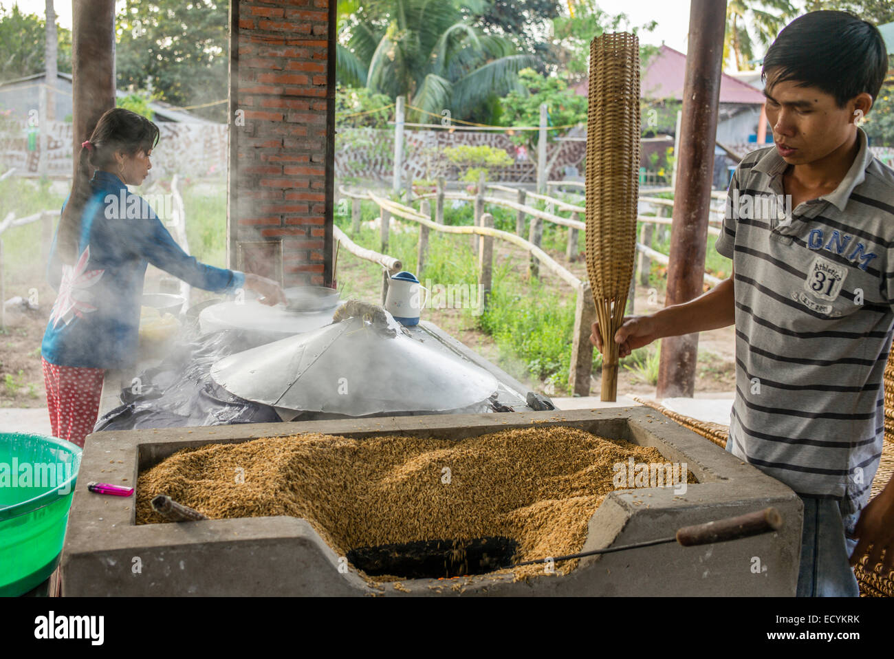 Vietnamese family working in their small home factory making rice paper ...