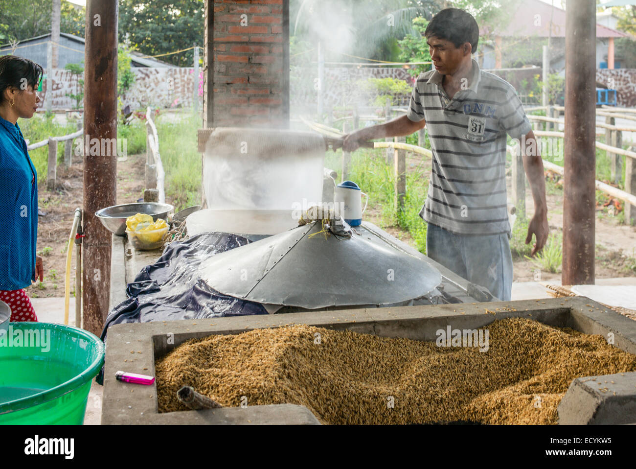 Vietnamese family working in their small home factory making rice paper ...