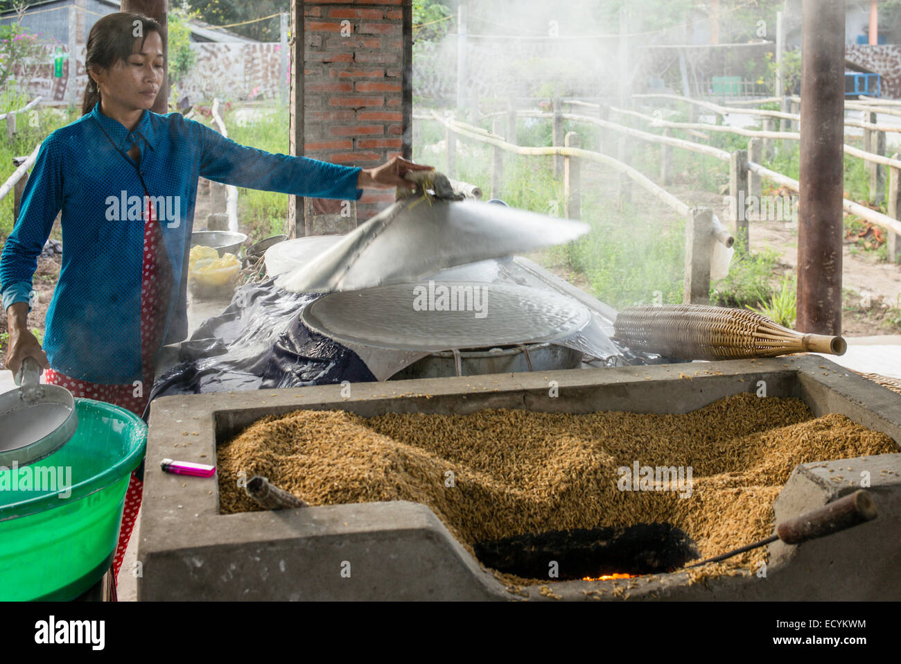 Vietnamese family working in their small home factory making rice paper ...
