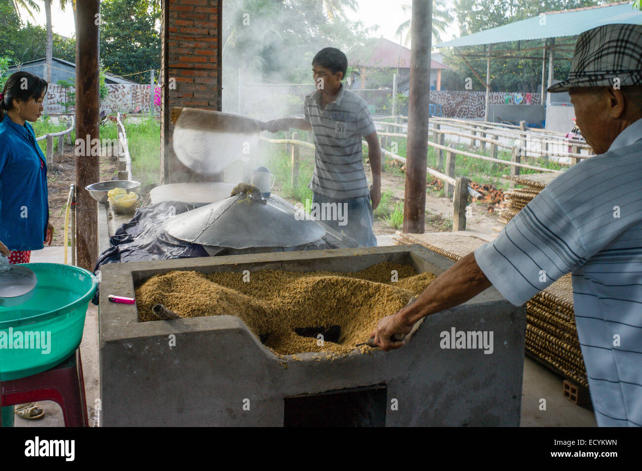 Vietnamese family working in their small home factory making rice paper ...