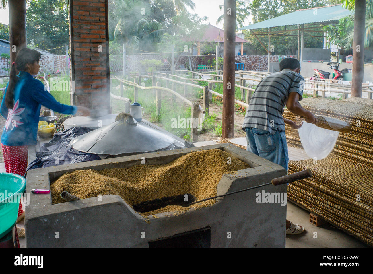 Vietnamese family working in their small home factory making rice paper ...