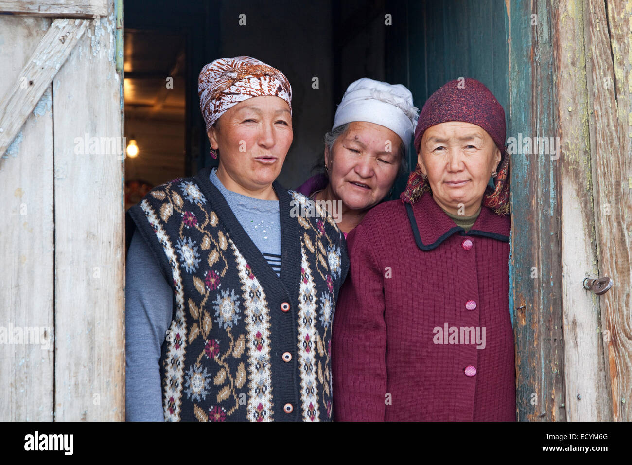 Three Kyrgyz women posing in doorway of house at village Sary-Tash ...