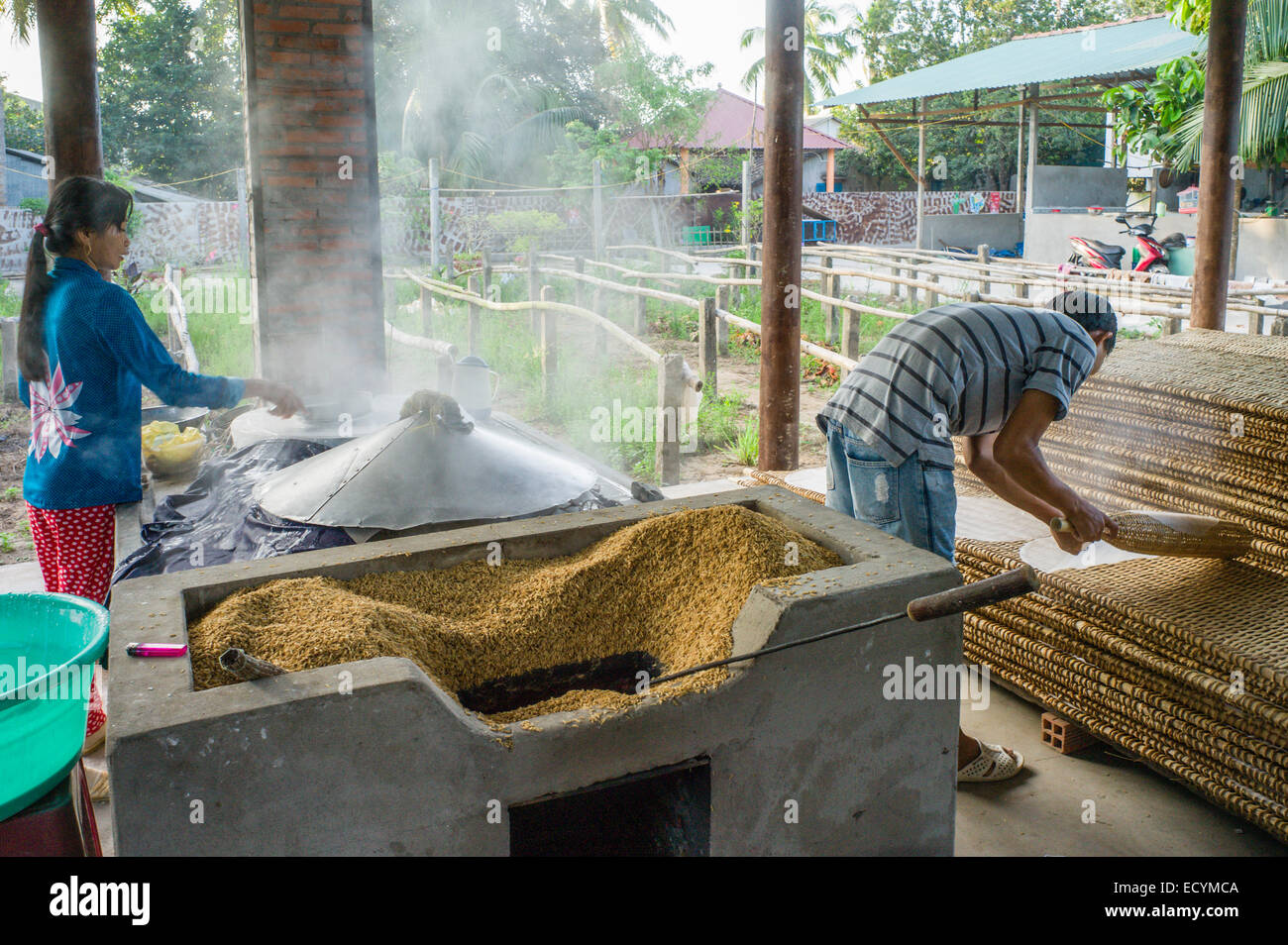 Vietnamese family working in their small home factory making rice paper ...