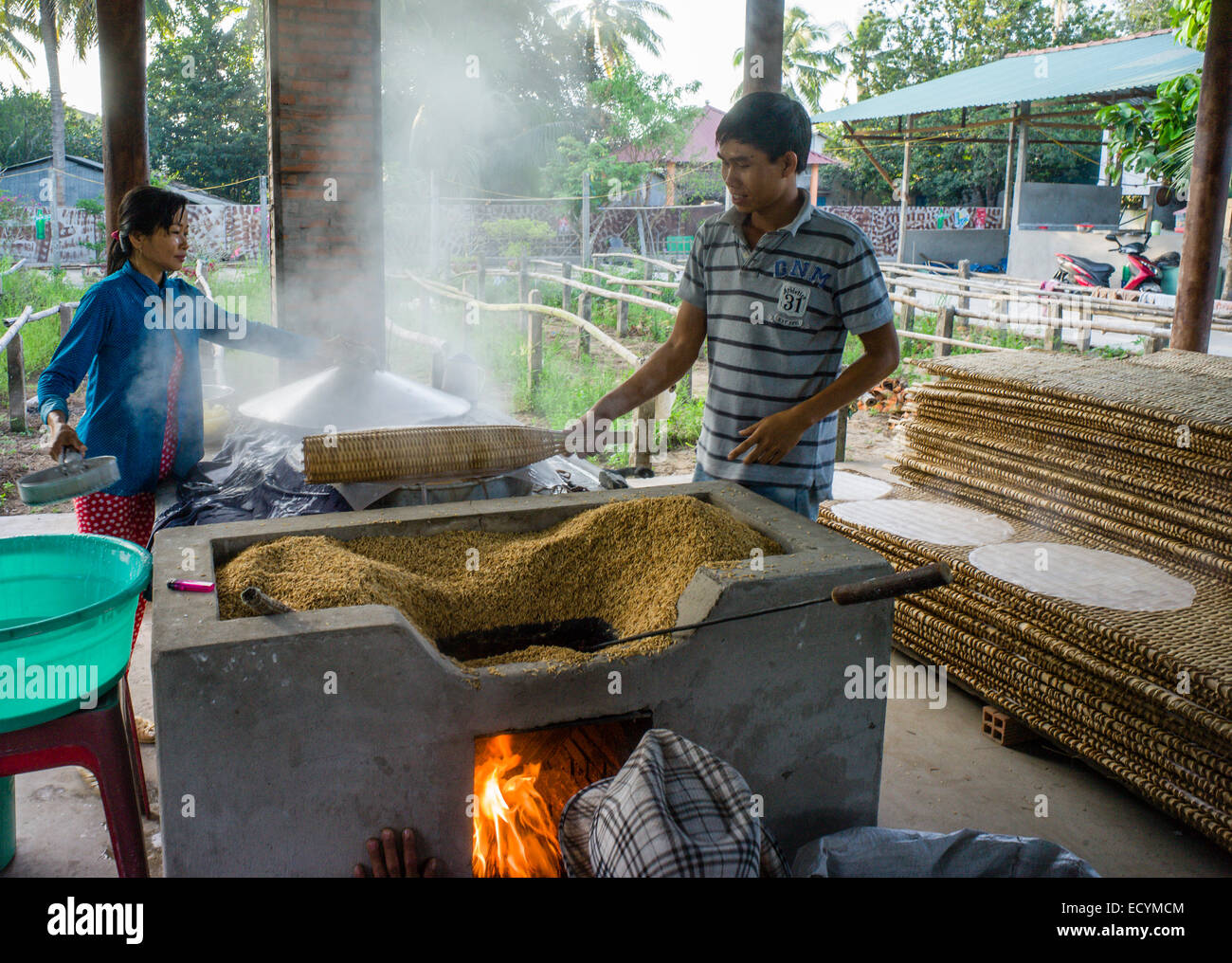 Vietnamese family working in their small home factory making rice paper ...