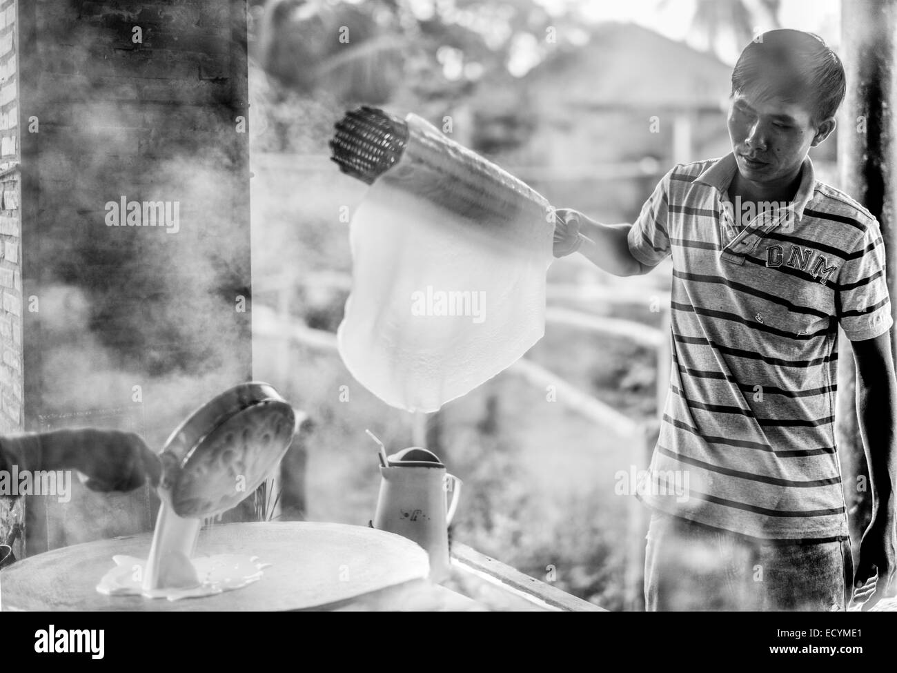 Vietnamese family working in their small home factory making rice paper ...