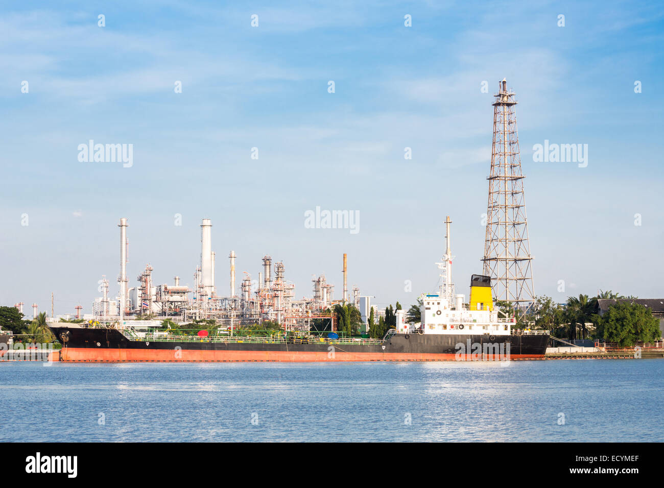 landscape of Oil refinery plant along river with tanker Stock Photo - Alamy