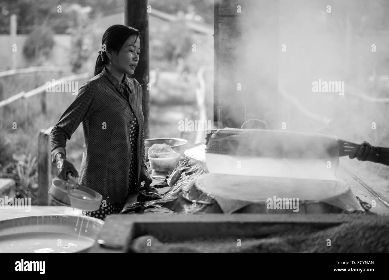 Vietnamese family working in their small home factory making rice paper ...