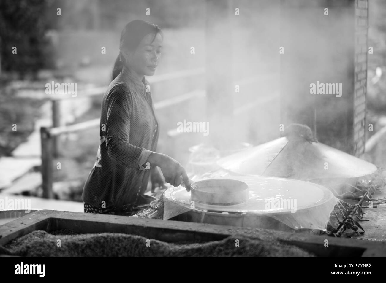 Vietnamese family working in their small home factory making rice paper ...