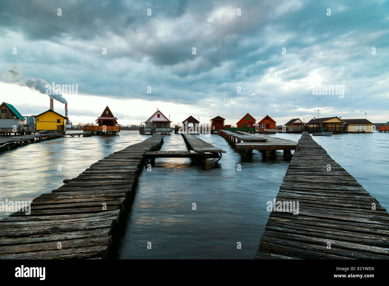 Sunset lake Bokod with pier and fishing wooden cottages, power plant in ...