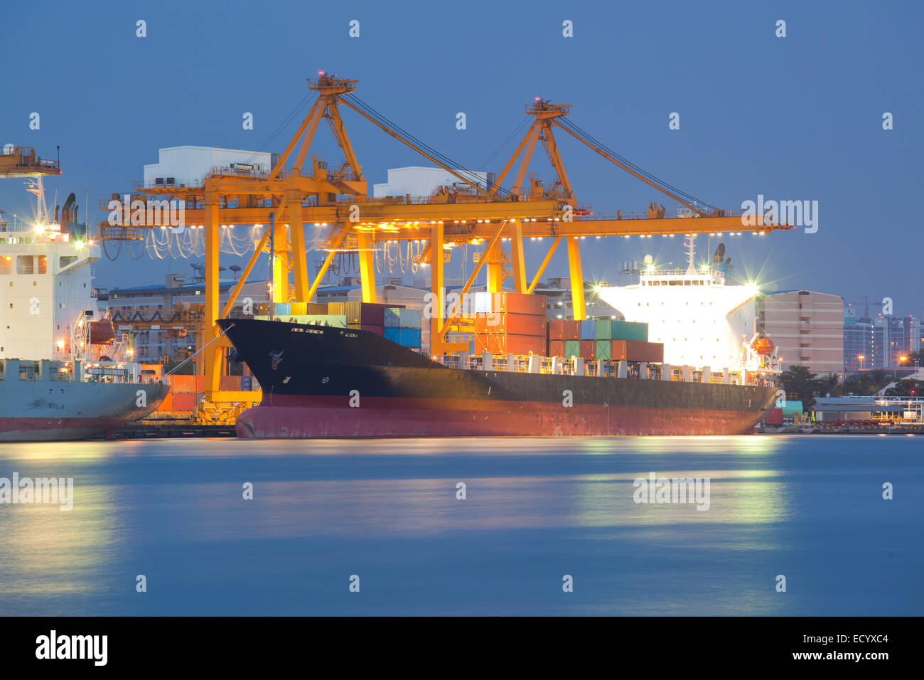 Container Cargo freight ship with working crane bridge in shipyard at ...