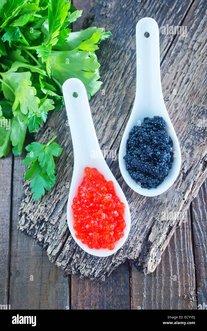 red and black caviar in white spoon and on a table Stock Photo - Alamy
