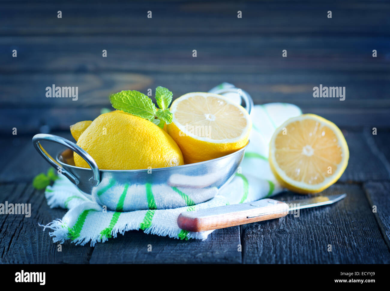 lemons in metal bowl and on a table Stock Photo - Alamy