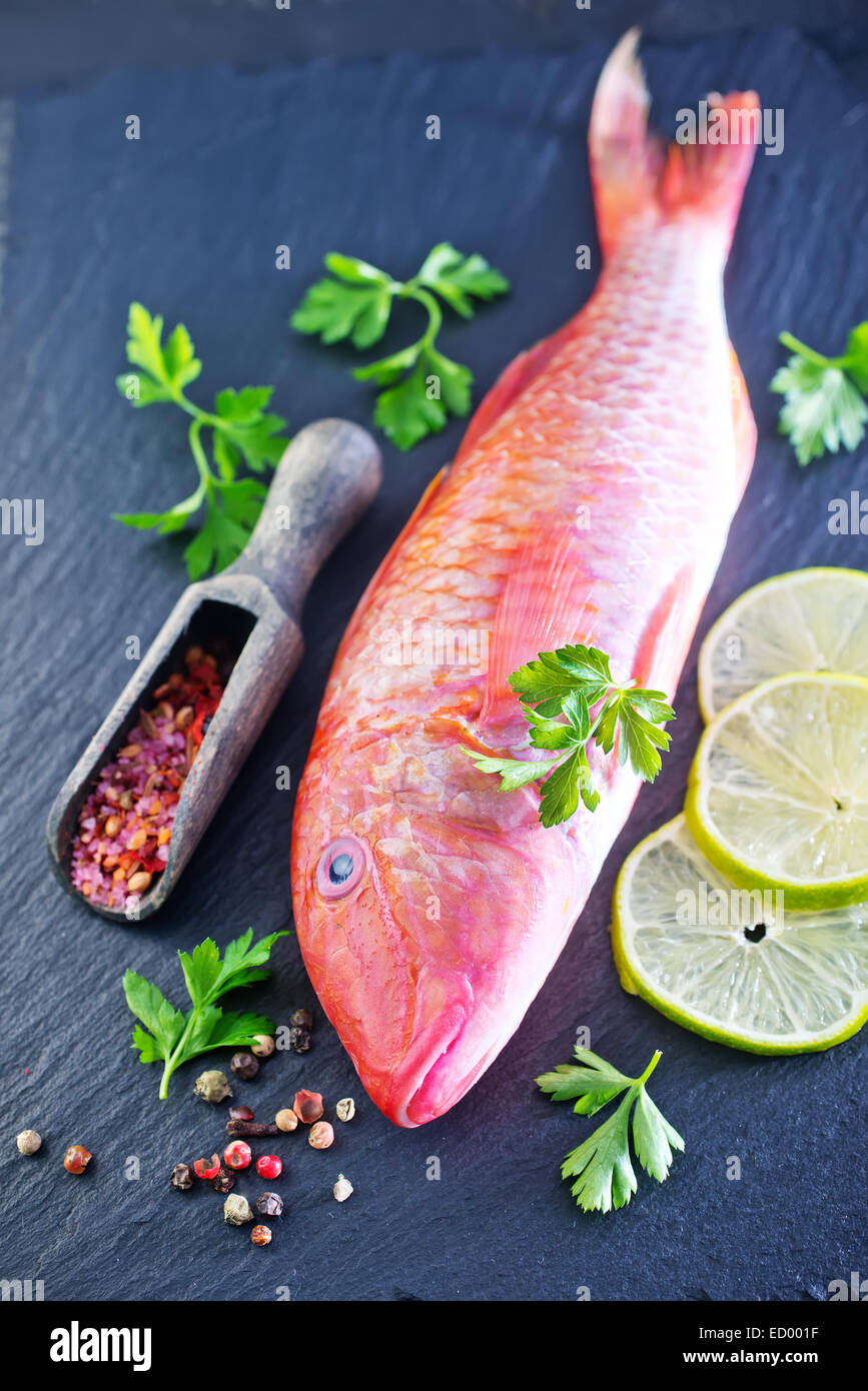 raw fish with spice on black board Stock Photo - Alamy