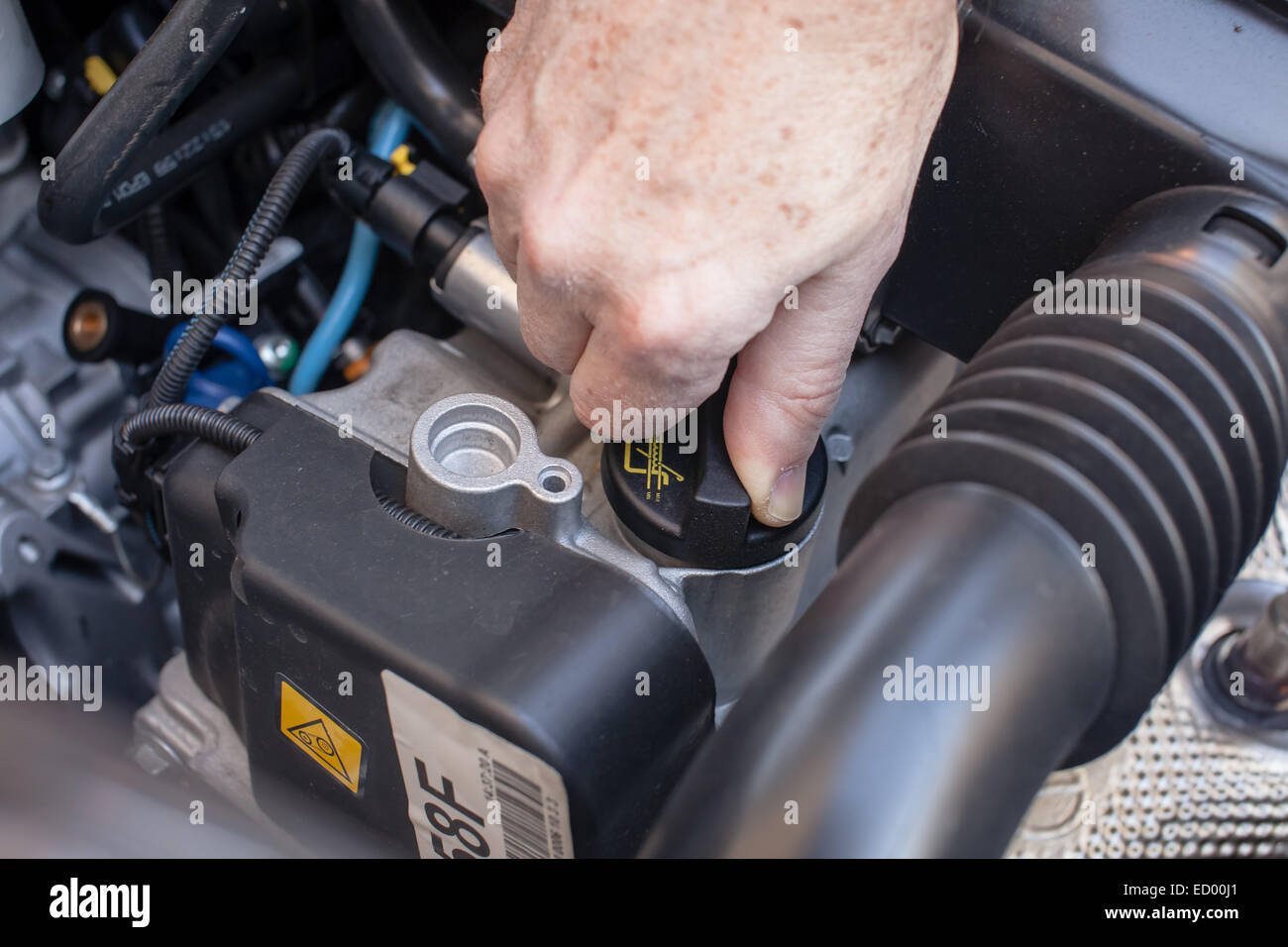 Hand checking the oil cap of a car engine Stock Photo - Alamy