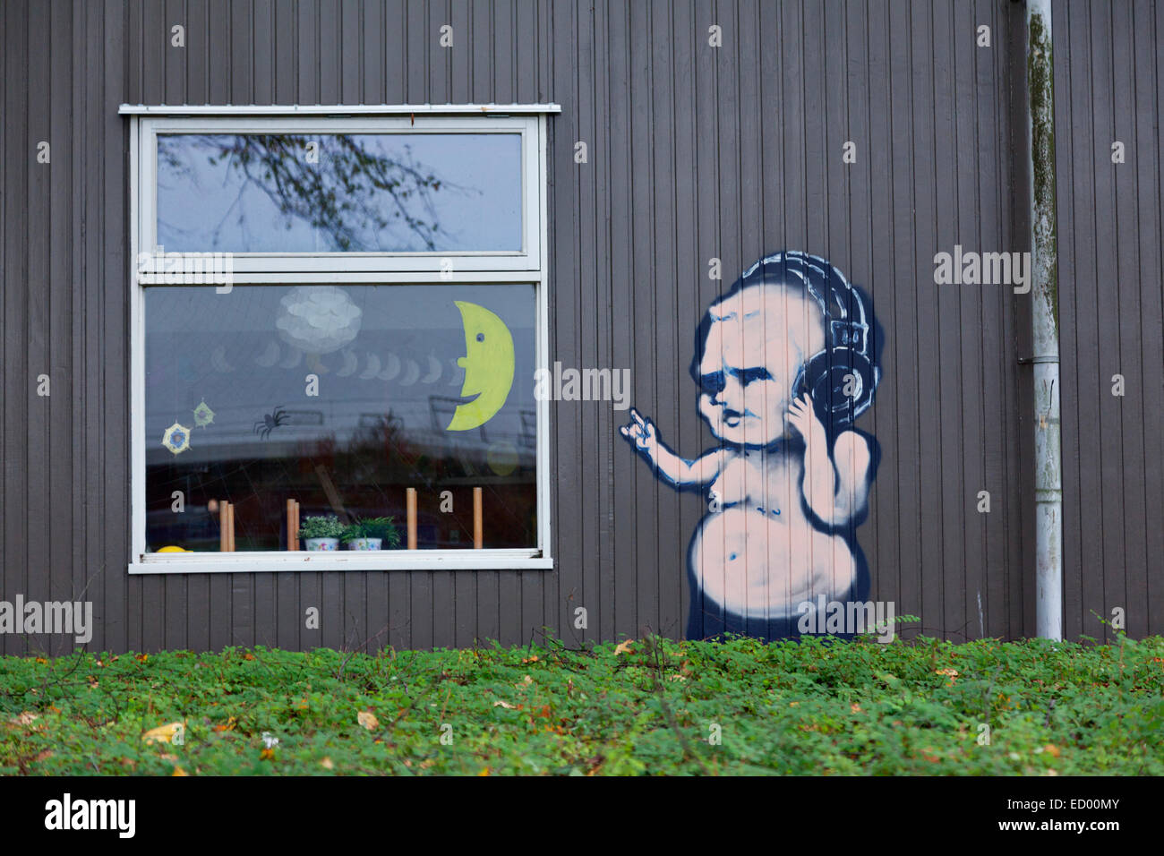 Graffiti of baby with headphones pointing at a moon painted on the ...