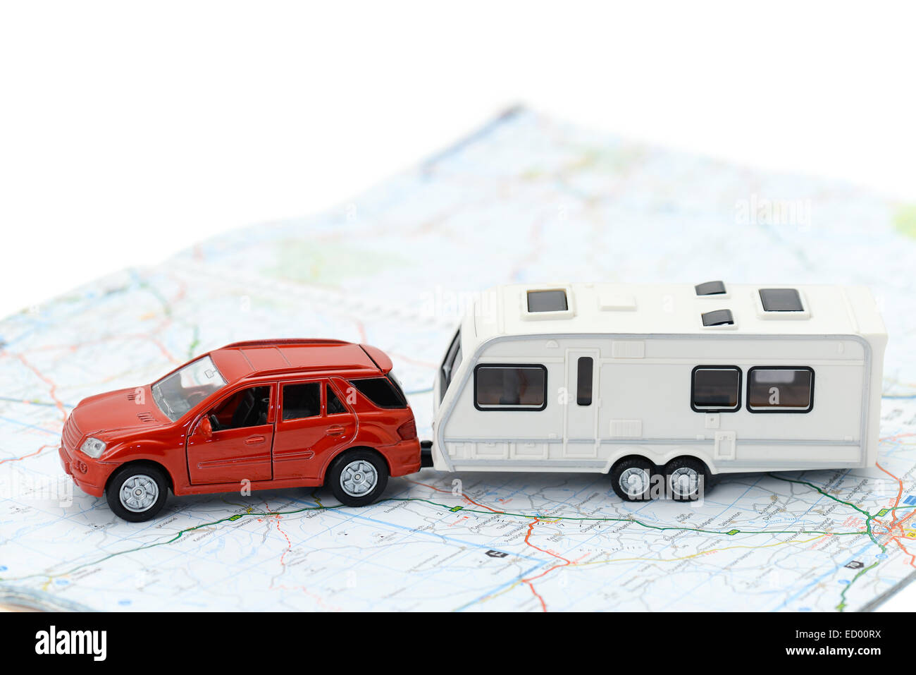 Car and a trailer caravan on a map - travel concept. Studio shot with a ...