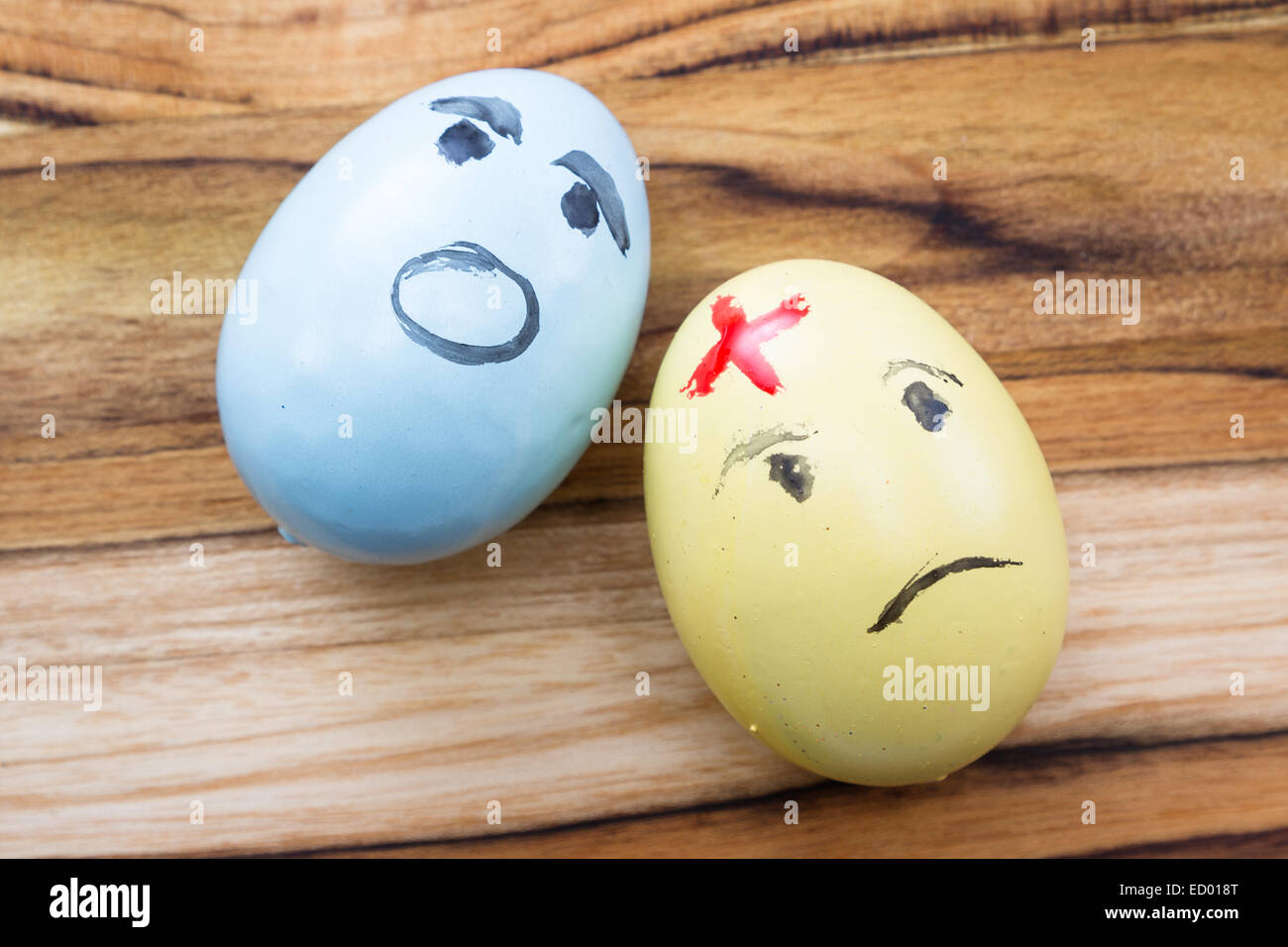 hand painted easter eggs with sad and scarred expressions on a wooden ...