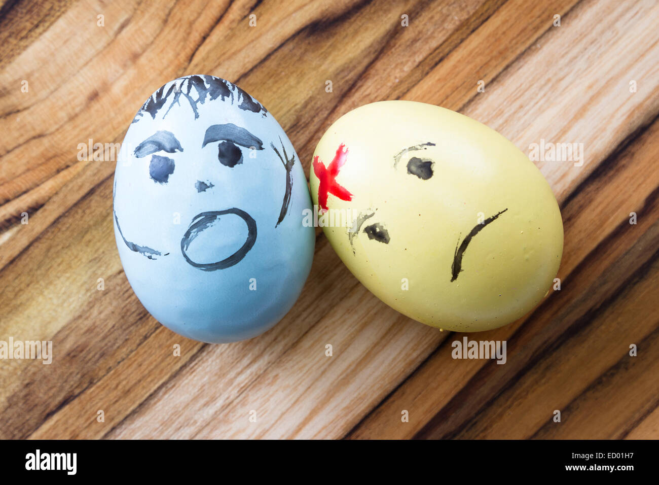 hand painted easter eggs with sad and scarred expressions on a wooden ...