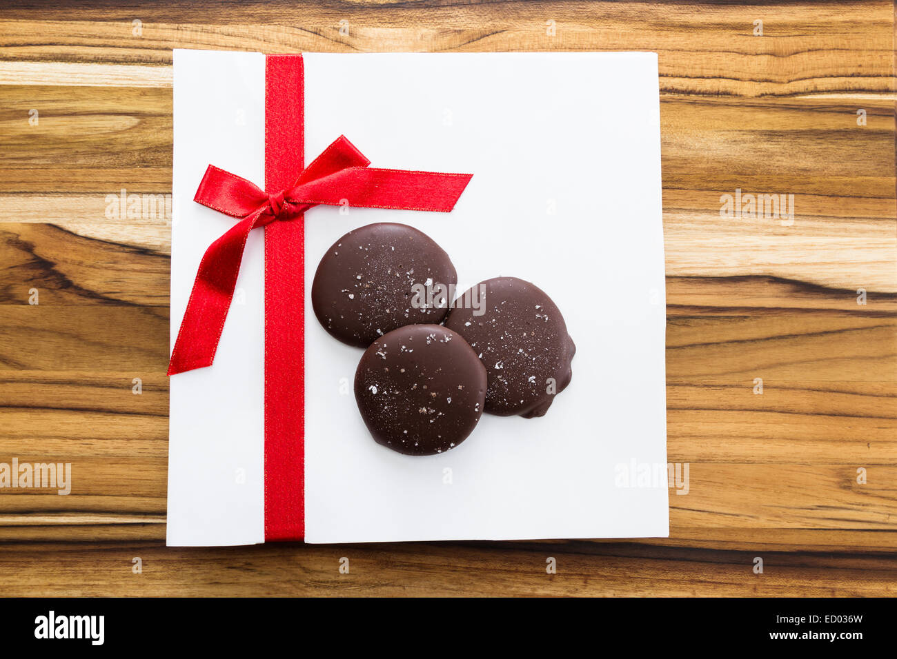 home made sea salted caramels on a white background with a red ribbon ...