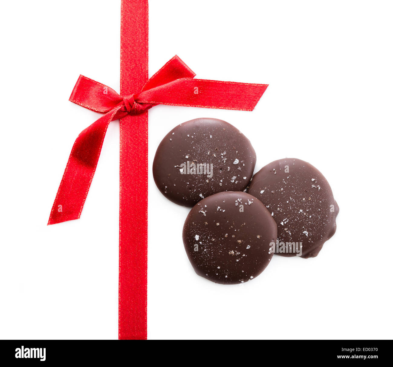 home made sea salted caramels with a red ribbon and bow isolated on a ...