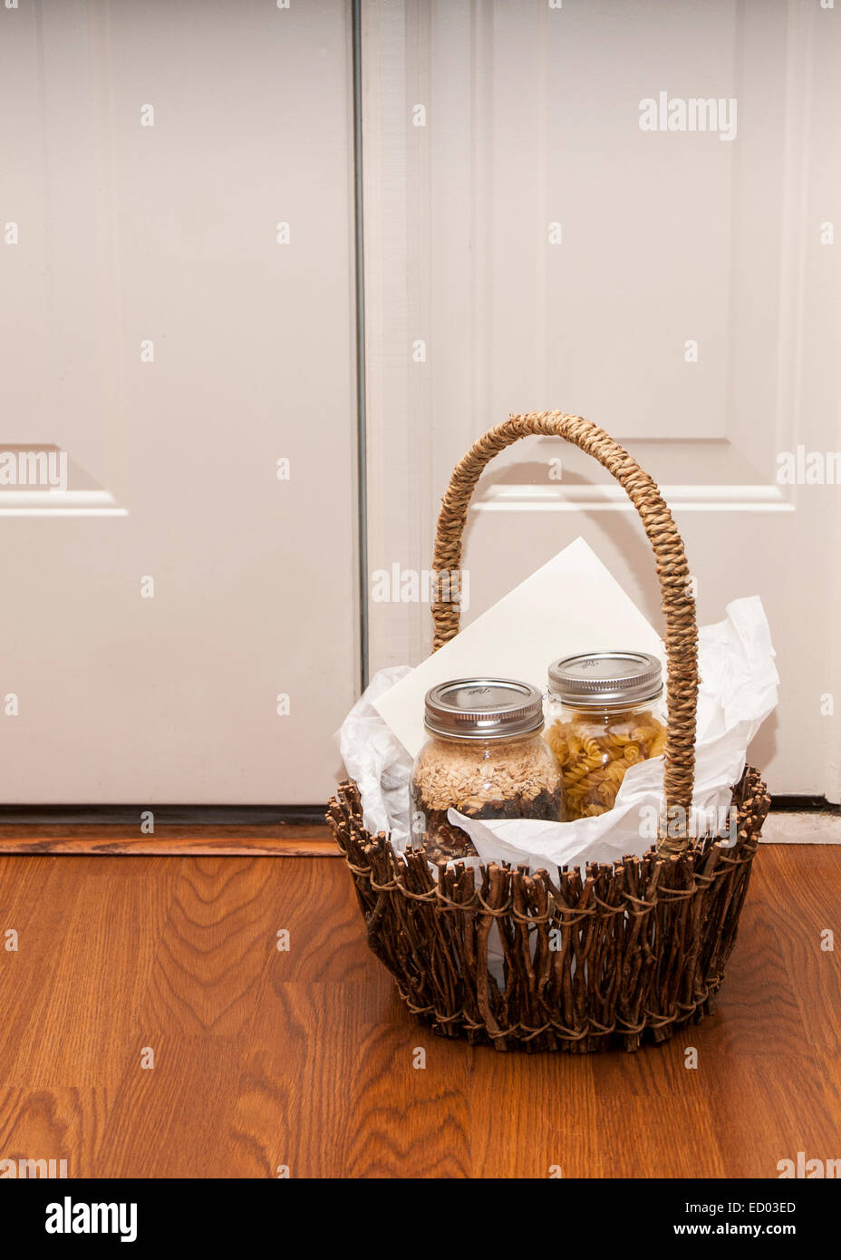Brown basket sitting by a door with two jars filled with product inside ...