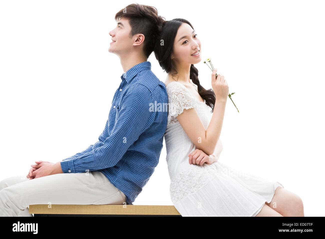 Happy young couple back to back Stock Photo - Alamy