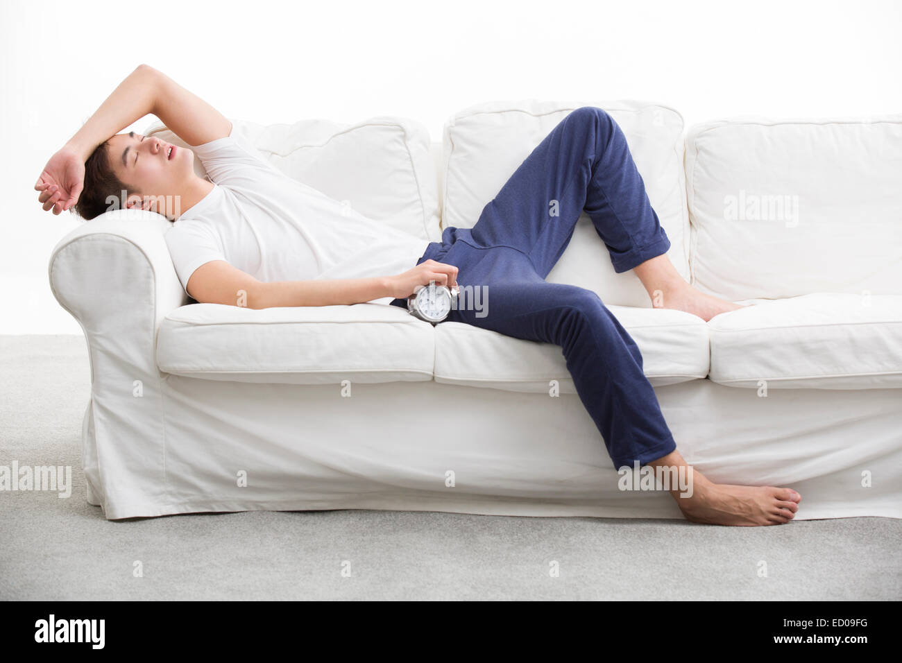 Young man sleeping on couch Stock Photo - Alamy