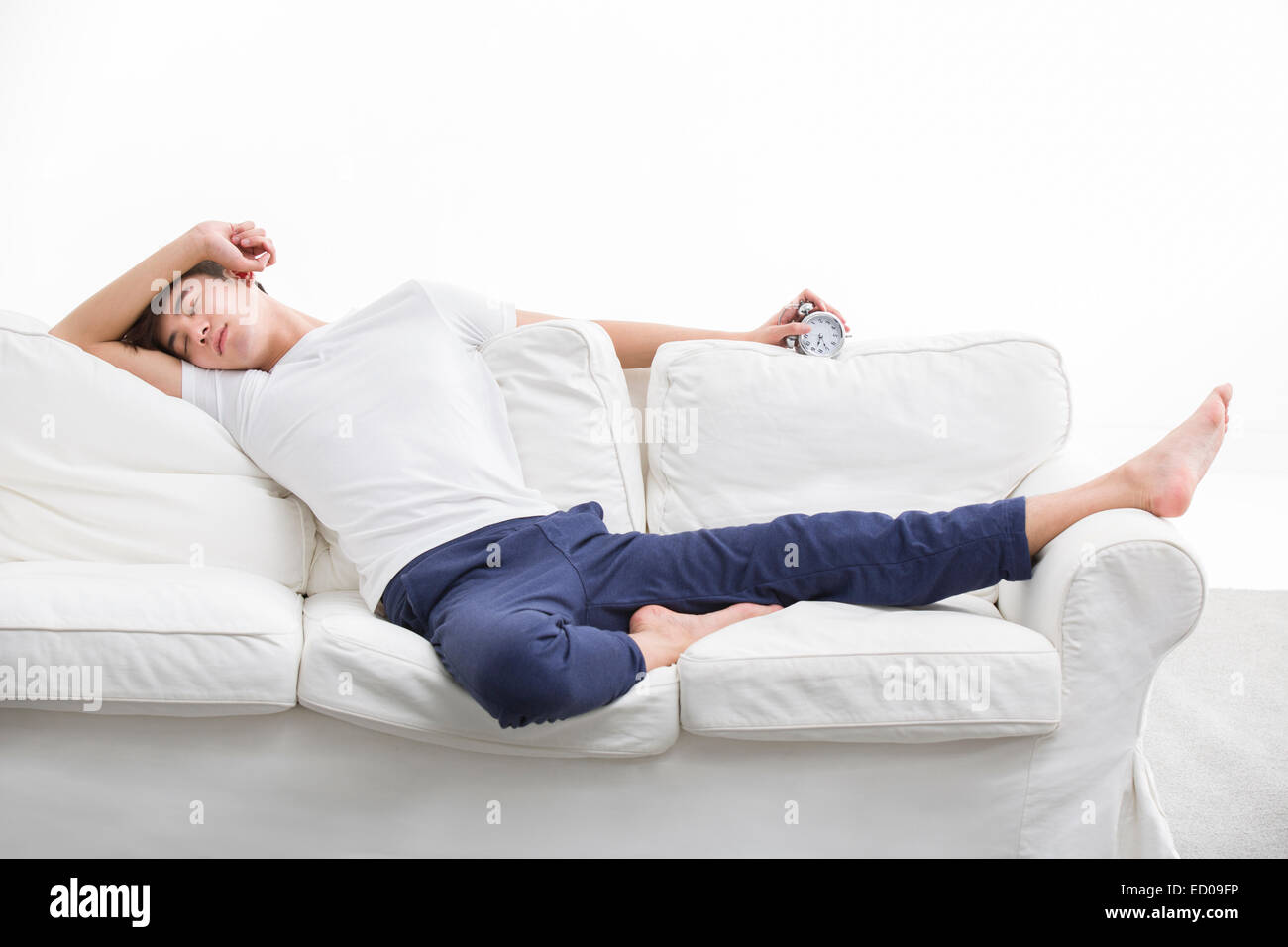 Young man sleeping on couch Stock Photo - Alamy