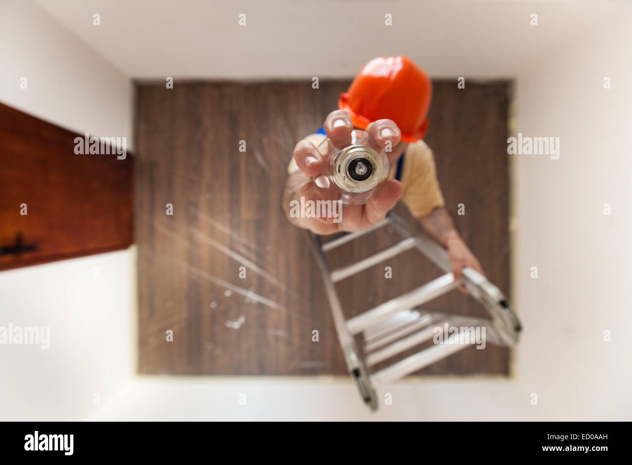 Electrician on the ladder is changing a burned out bulb Stock Photo - Alamy