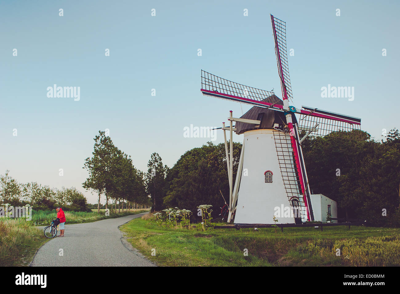 Man standing on road next to old fashioned windmill hi-res stock ...