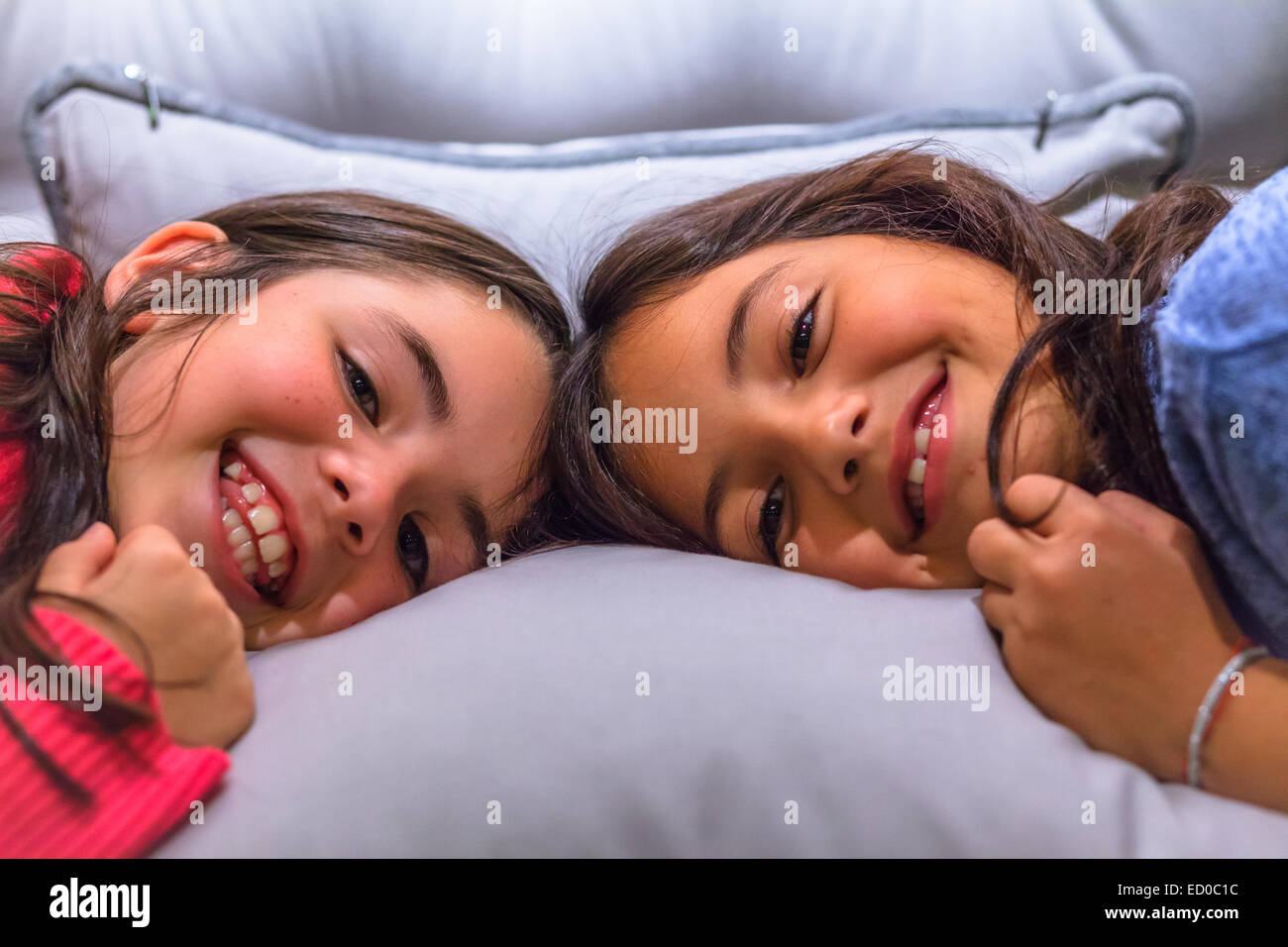 Portrait of two smiling girls lying on a bed Stock Photo - Alamy Portrait of two smiling girls lying on a bed Stock Photo - Alamy