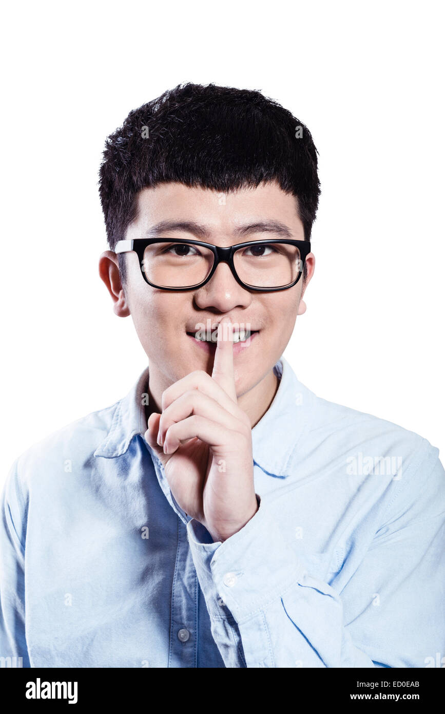 Young man with finger on lips Stock Photo - Alamy