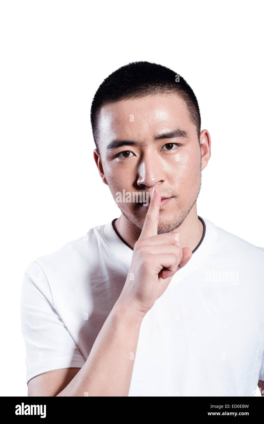 Young man with finger on lips Stock Photo - Alamy