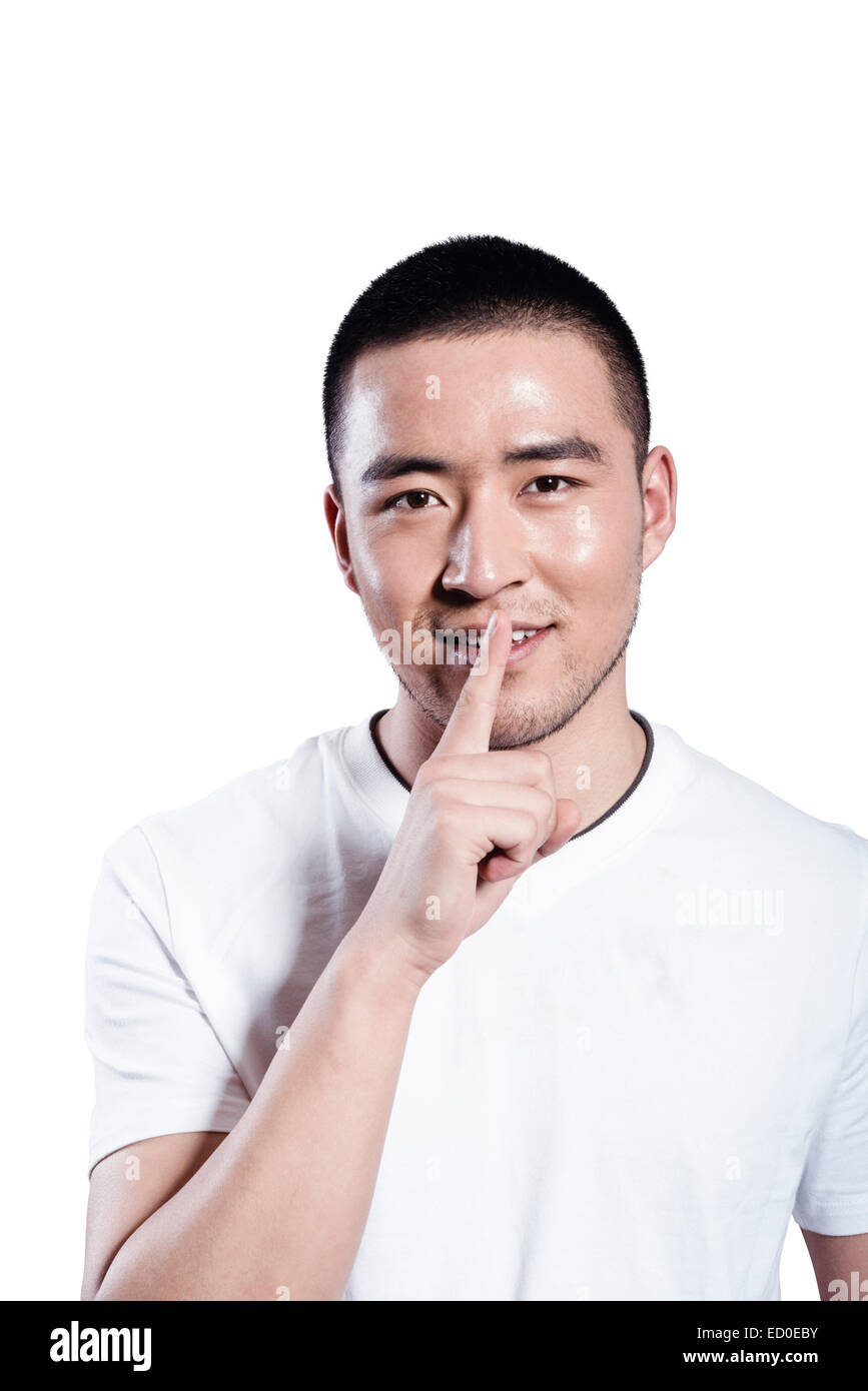 Young man with finger on lips Stock Photo - Alamy