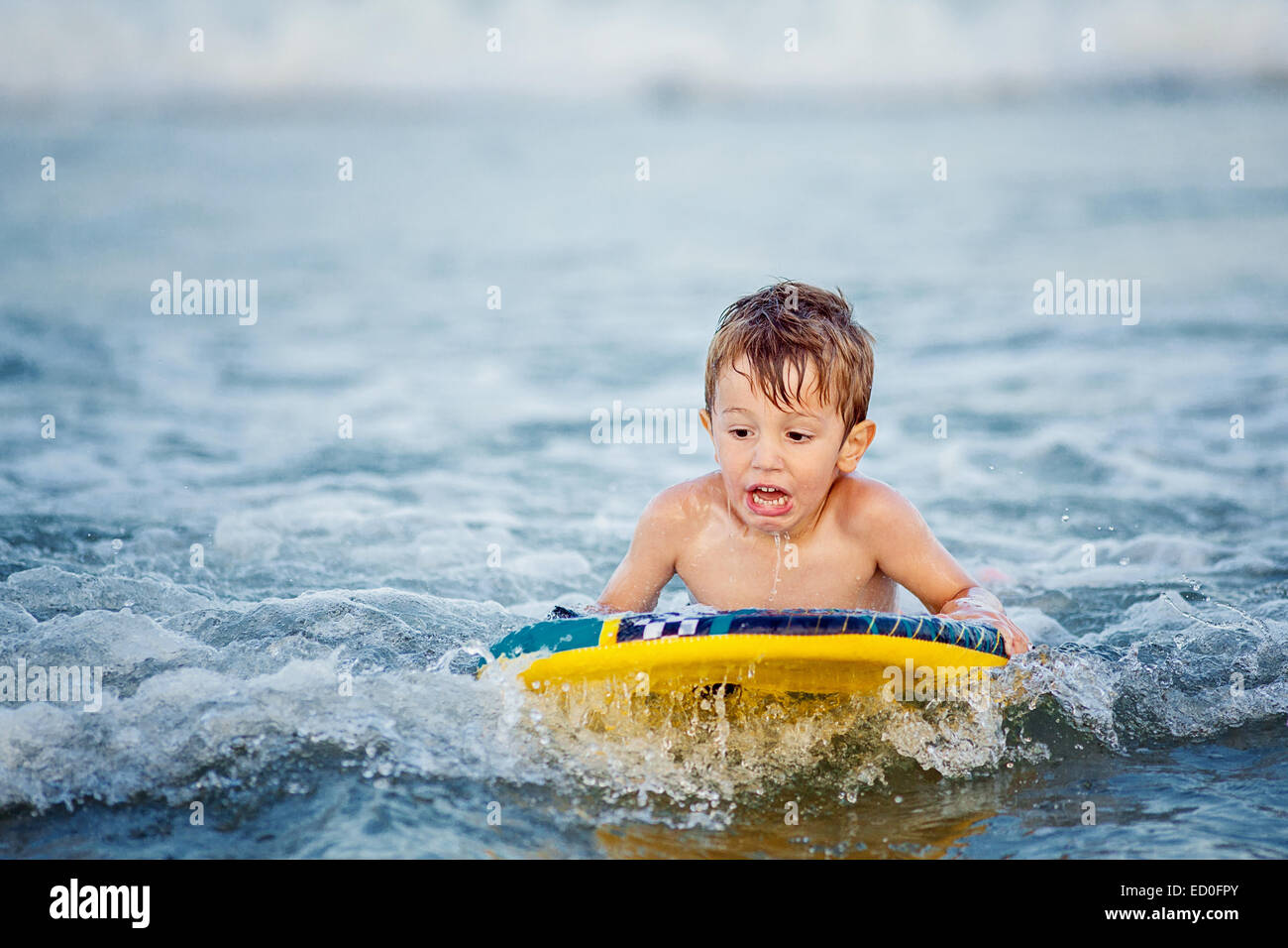 Portrait of a boy boogie boarding in sea Stock Photo - Alamy