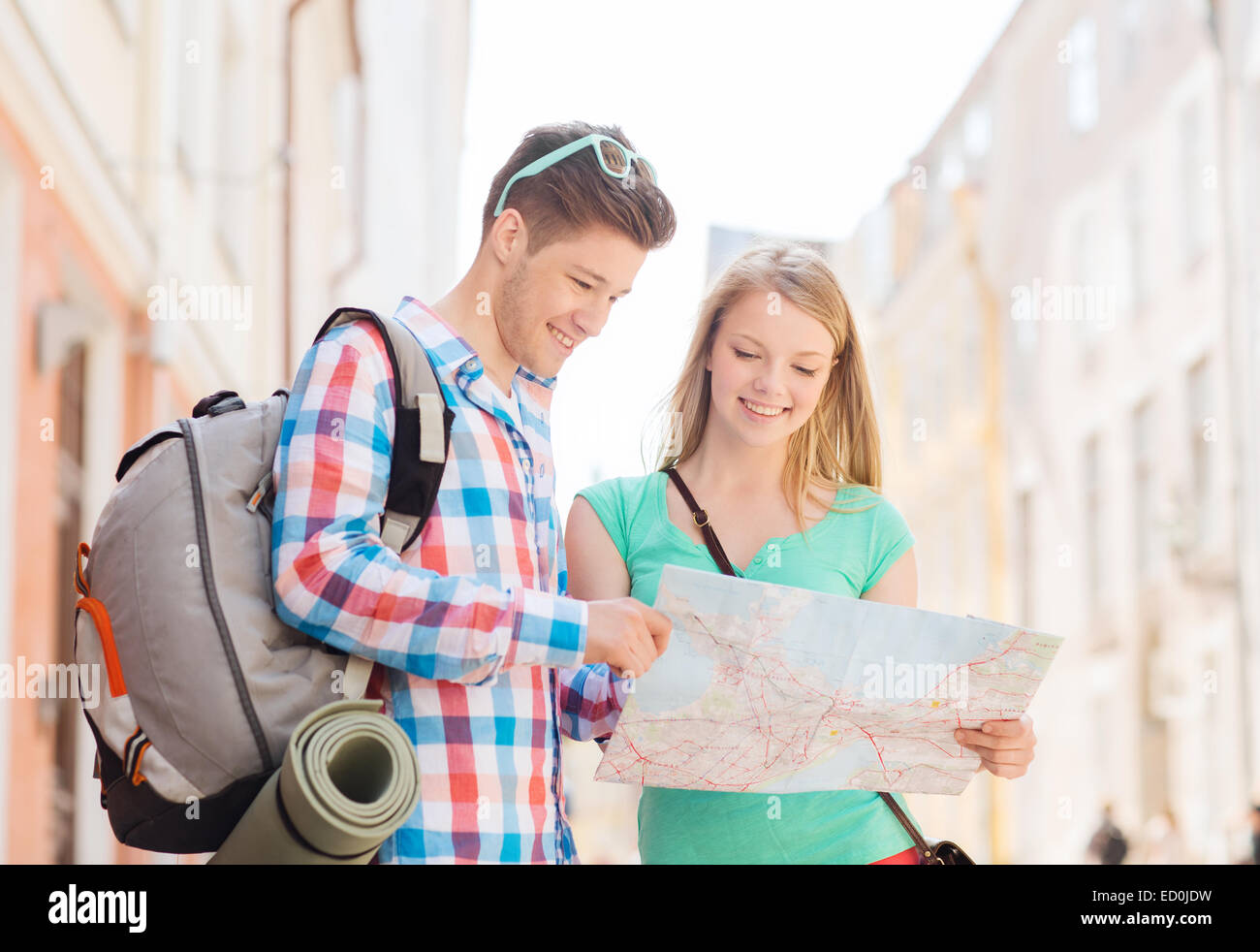 smiling couple with map and backpack in city Stock Photo - Alamy