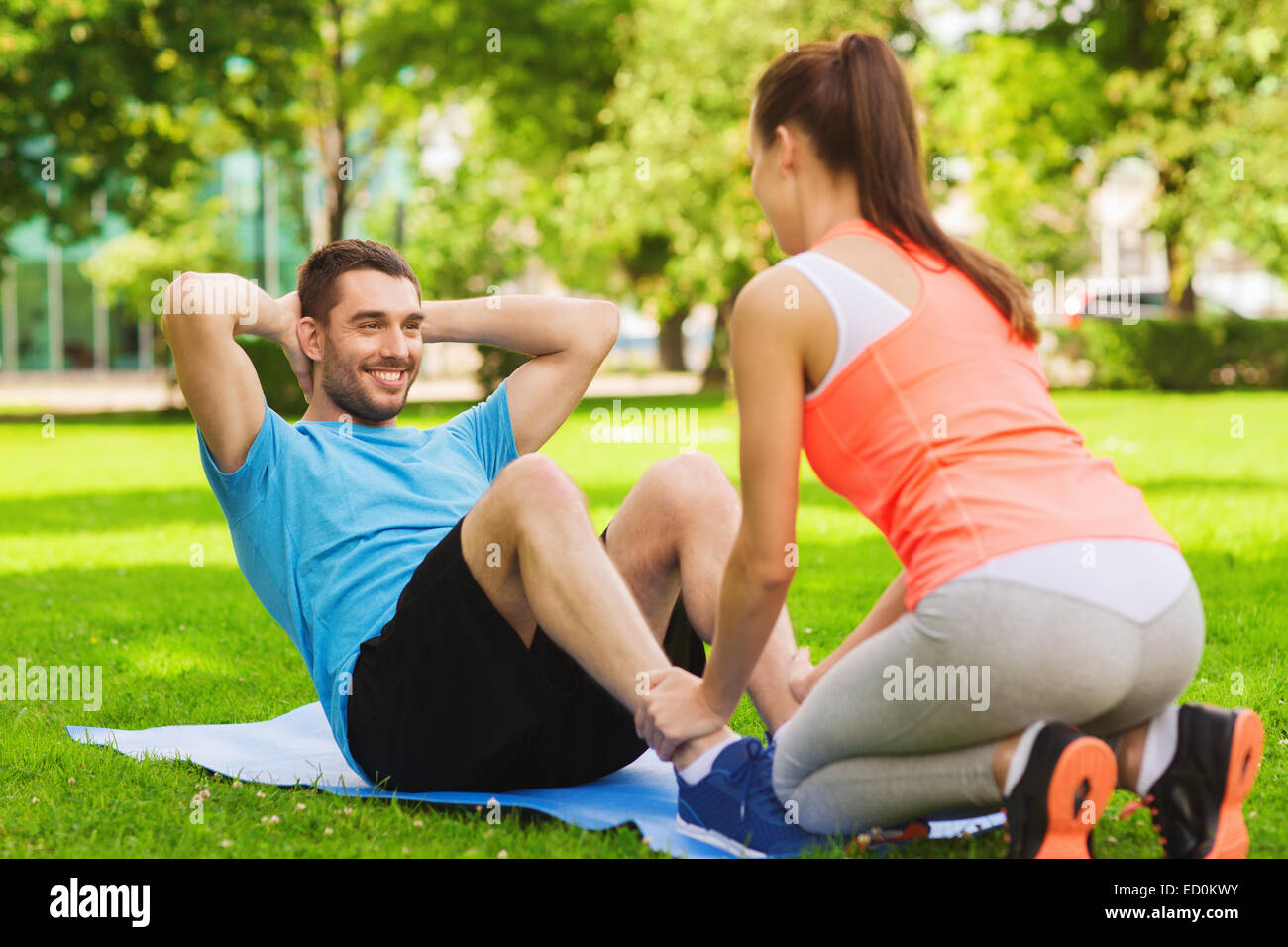 smiling man doing exercises on mat outdoors Stock Photo - Alamy