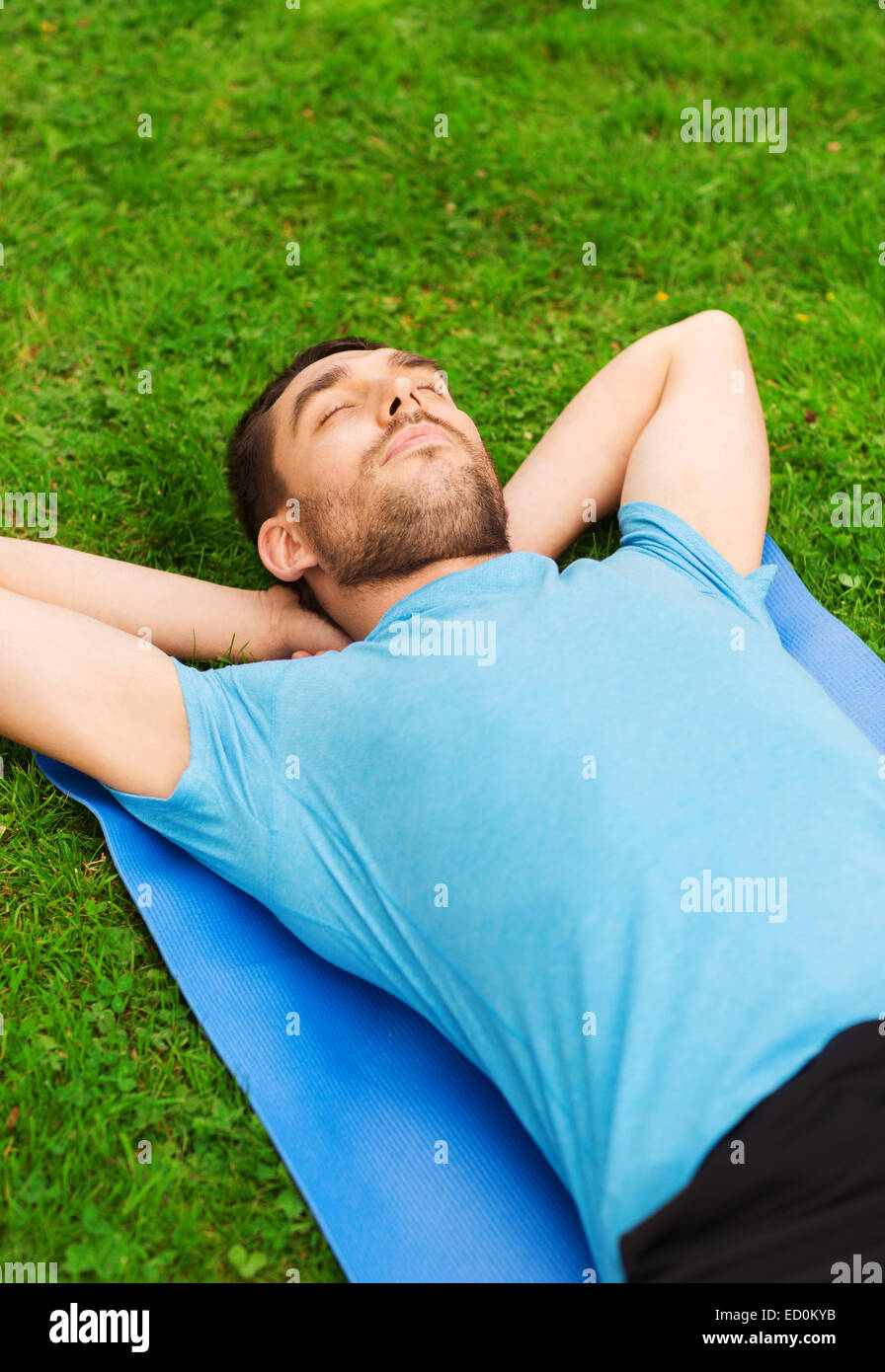 smiling man lying on mat outdoors Stock Photo - Alamy