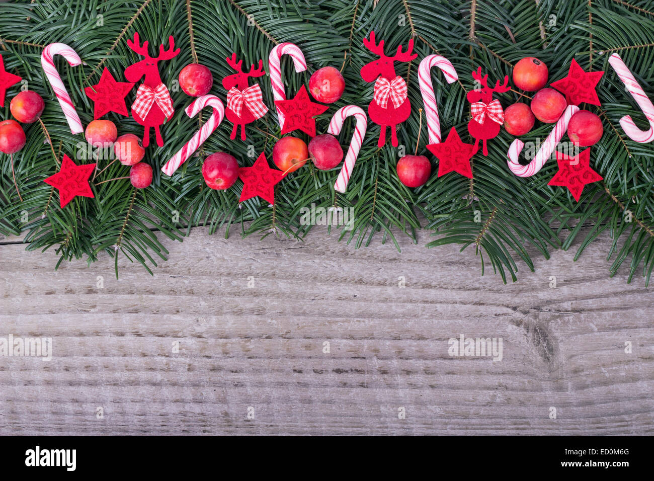 Pine green, candy Canes, apples and stars on wooden background Stock ...