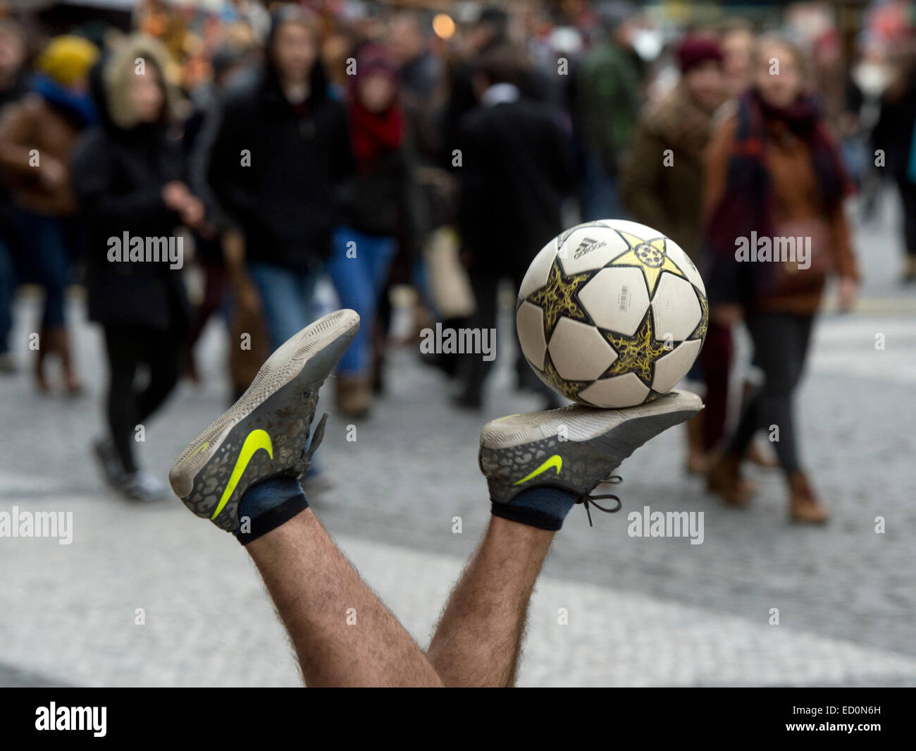 Tourists look on an acrobat juggling with a ball as temperature reaches ...