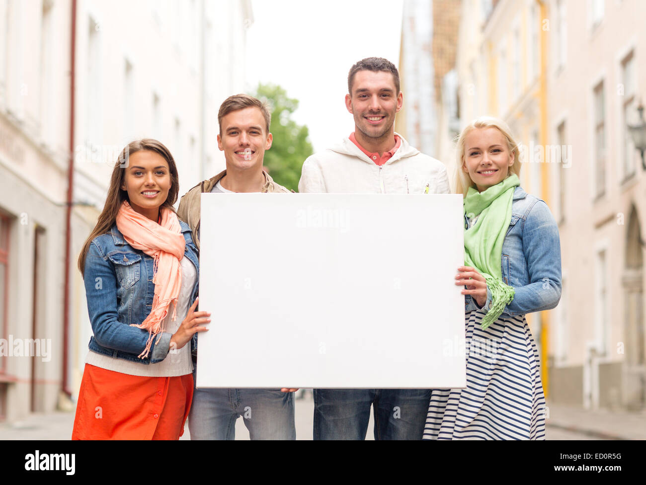 group of smiling friends with blank white board Stock Photo - Alamy