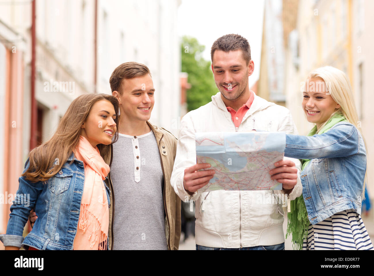 group of smiling friends with map exploring city Stock Photo - Alamy