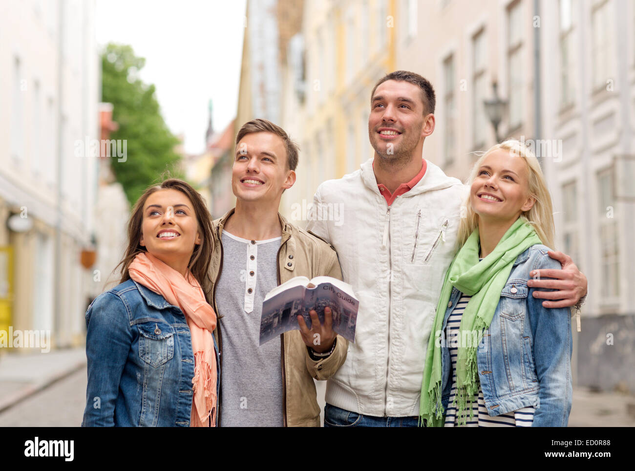 group of friends with city guide exploring town Stock Photo - Alamy