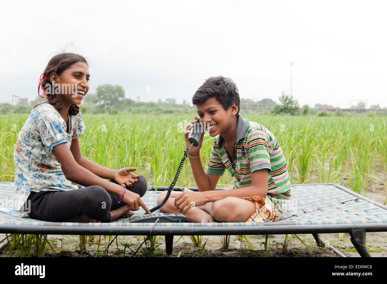 2 indian rural child field talking phone Stock Photo - Alamy