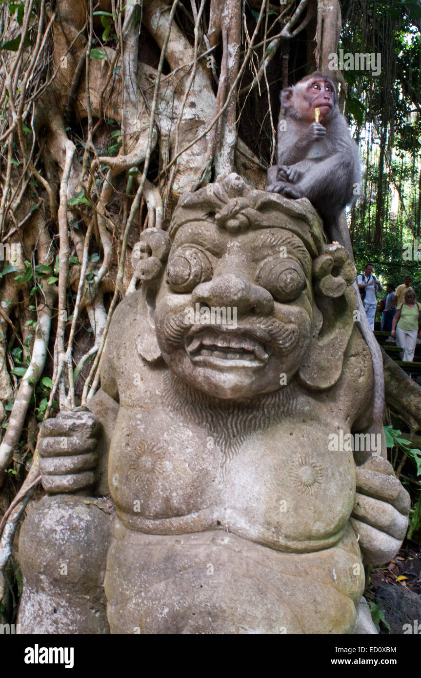 Monkeys having fun on stone statues of Hindu Holy Monkey Forest. Ubud ...