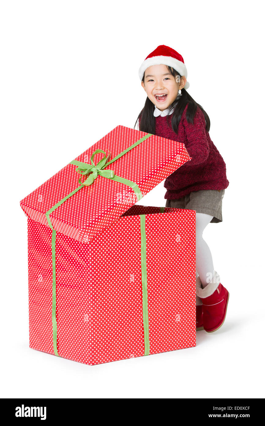 Happy girl unwrapping Christmas gift Stock Photo - Alamy
