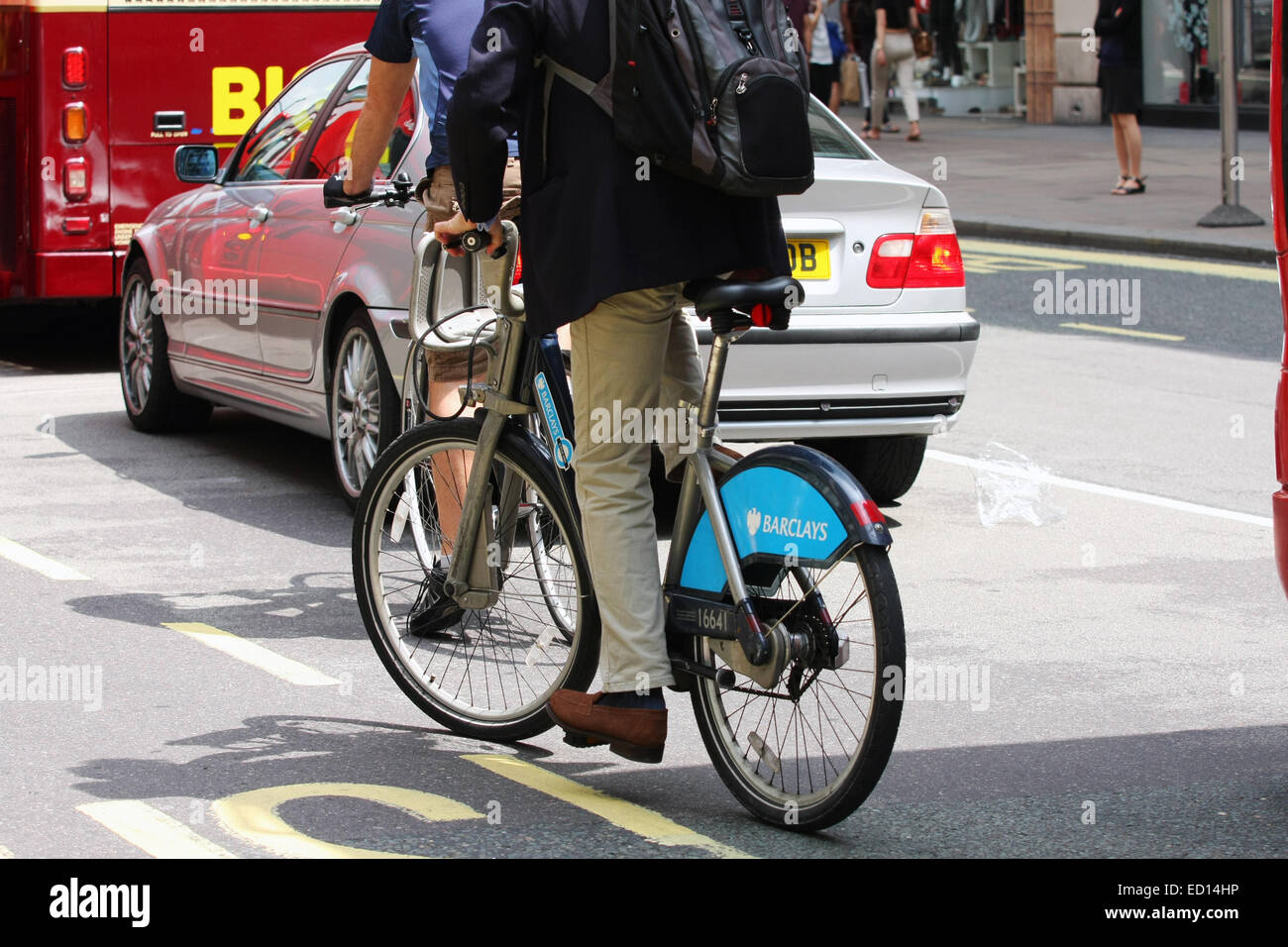A cyclist riding in a queue of traffic in London Stock Photo - Alamy