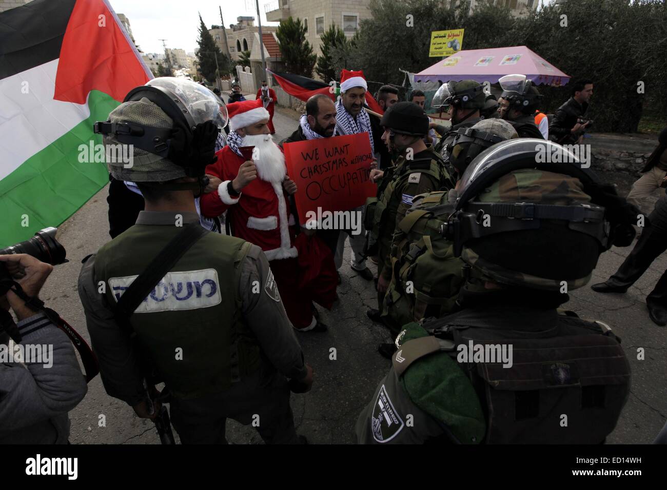 Bethlehem. 23rd Dec, 2014. Palestinian protesters wearing Santa Claus ...