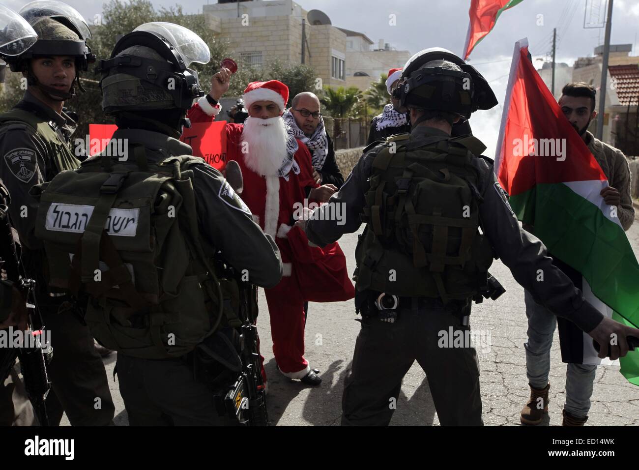 Bethlehem. 23rd Dec, 2014. Palestinian protesters wearing Santa Claus ...