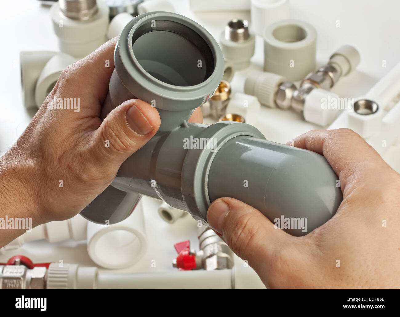 Set plumbing fittings in his hand Stock Photo - Alamy